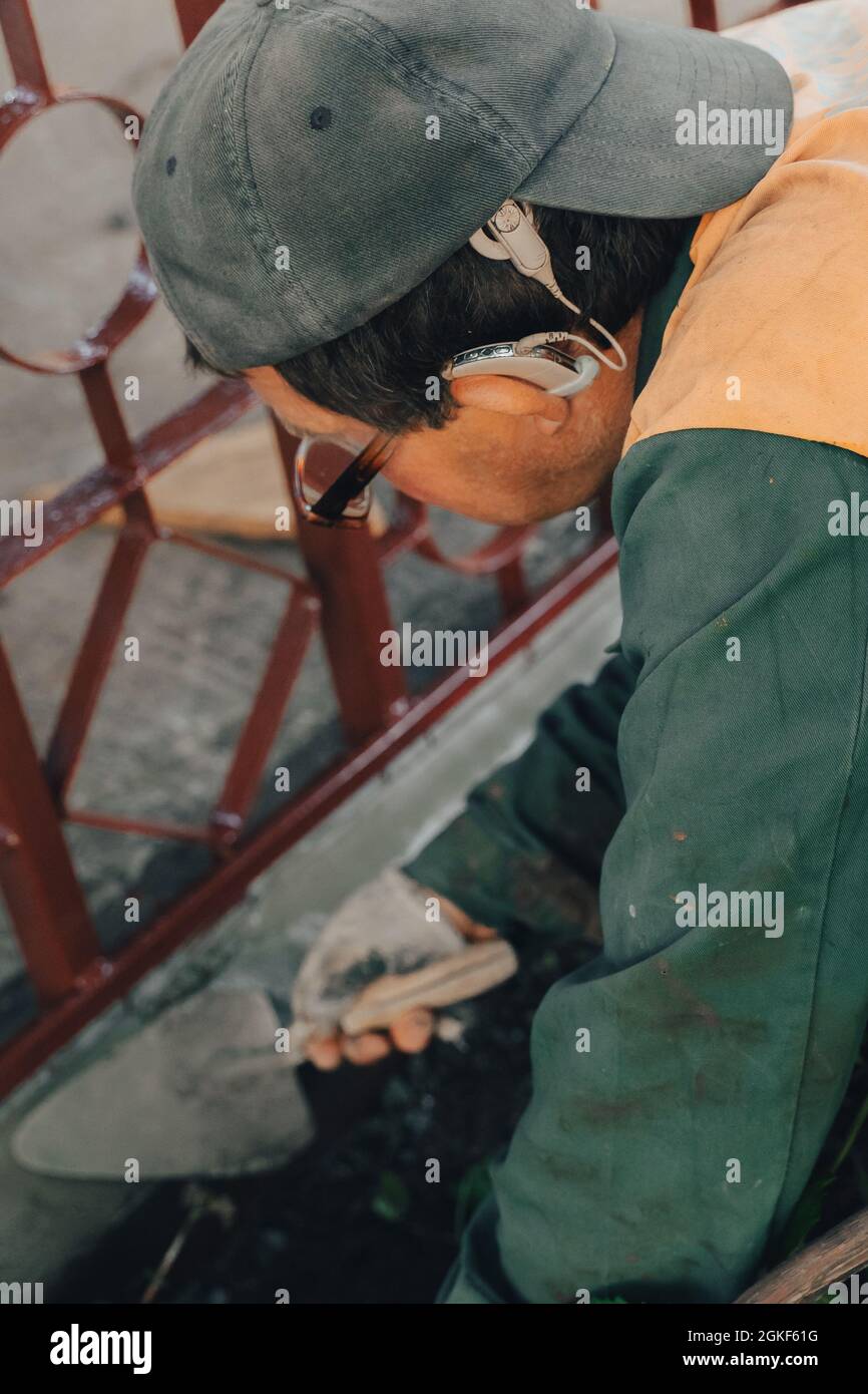 Construction technicians with hearing aid working with cement paving ...