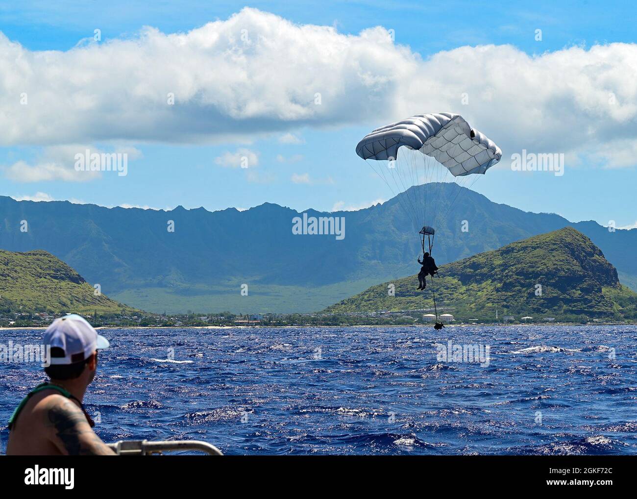 A Navy SEAL parachutes into the water near Joint Base Pearl Harbor ...