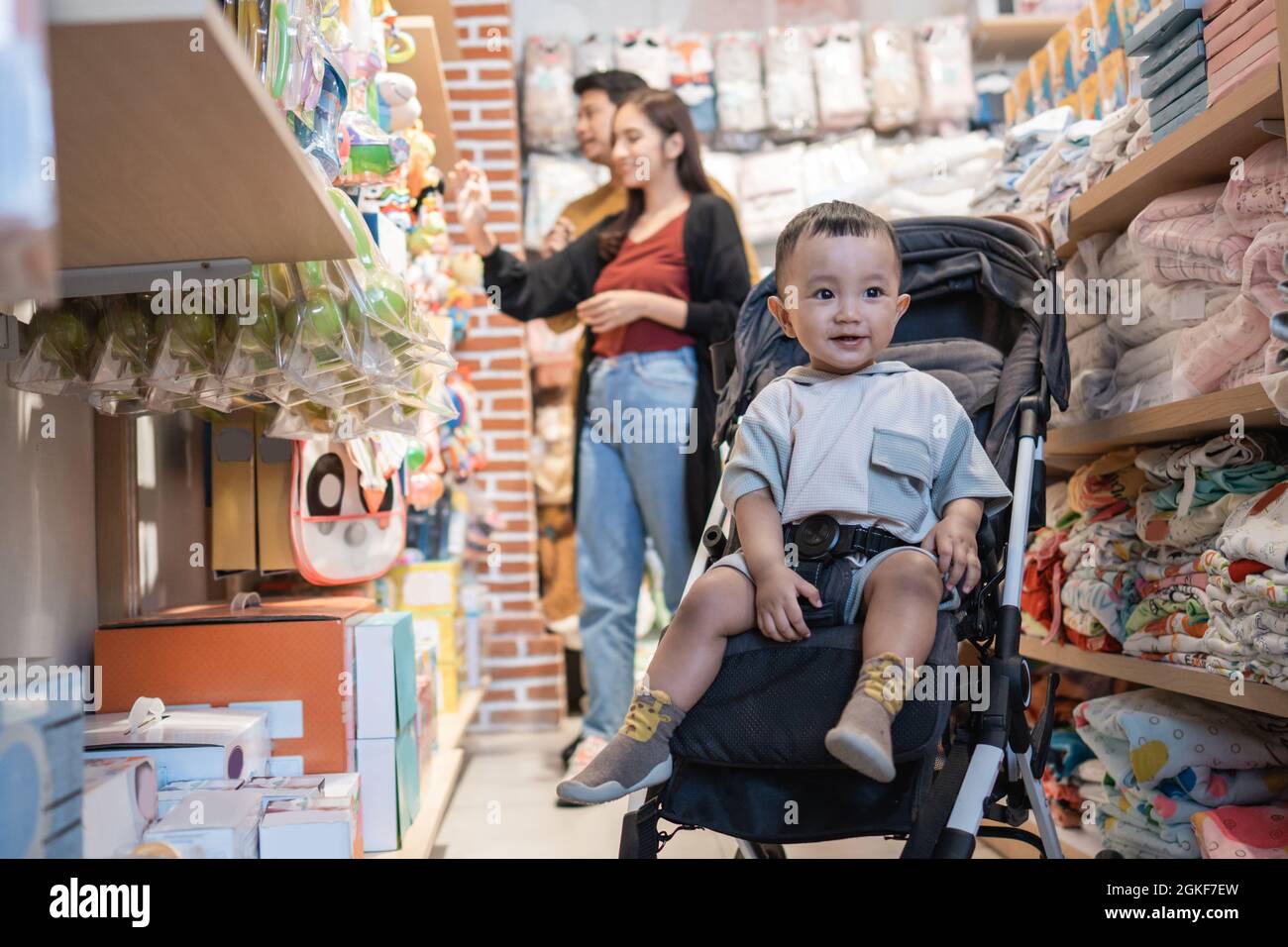 father and mother shopping at the baby shop with their son in the ...