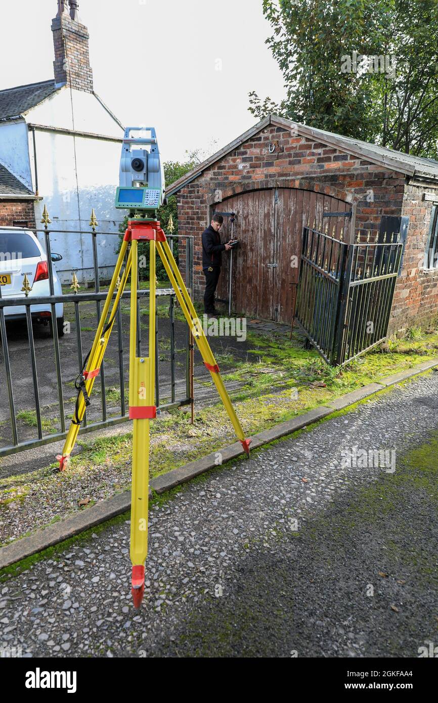 A surveyor undertaking a topographical survey using a Leica pinpoint ...