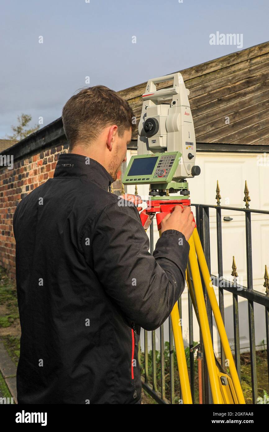 A surveyor undertaking a topographical survey using a Leica pinpoint ...
