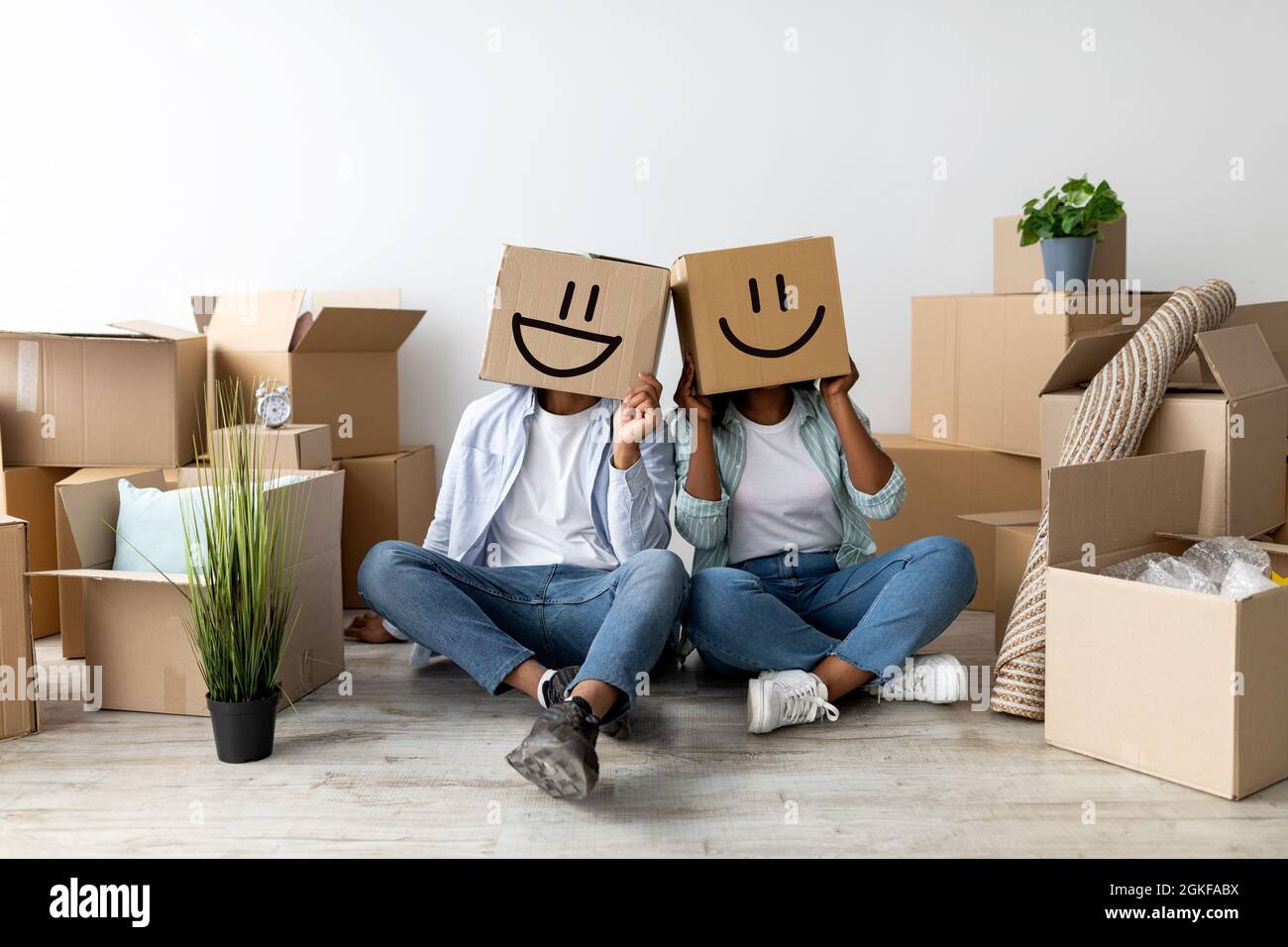 Moving and real estate concept. Black couple with cardboard boxes with ...