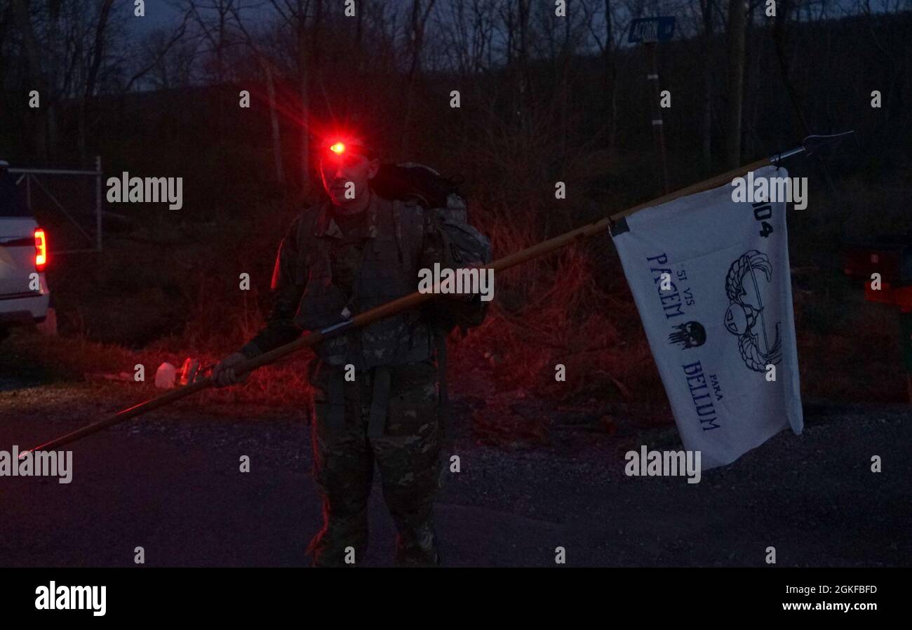 Carrying the class guidon, a Soldier finishes the 6-mile ruck march ...