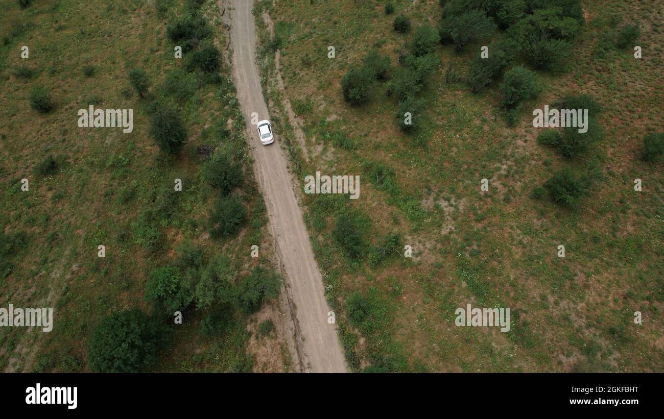 Flying above the countryside summer landscape with a driving lonely car ...
