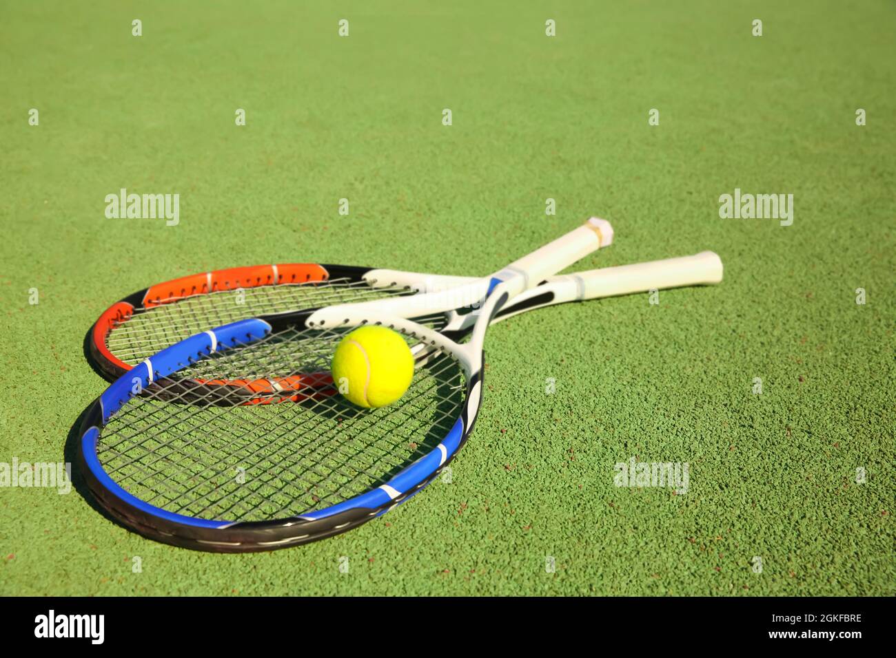 Tennis ball and rackets on court Stock Photo - Alamy
