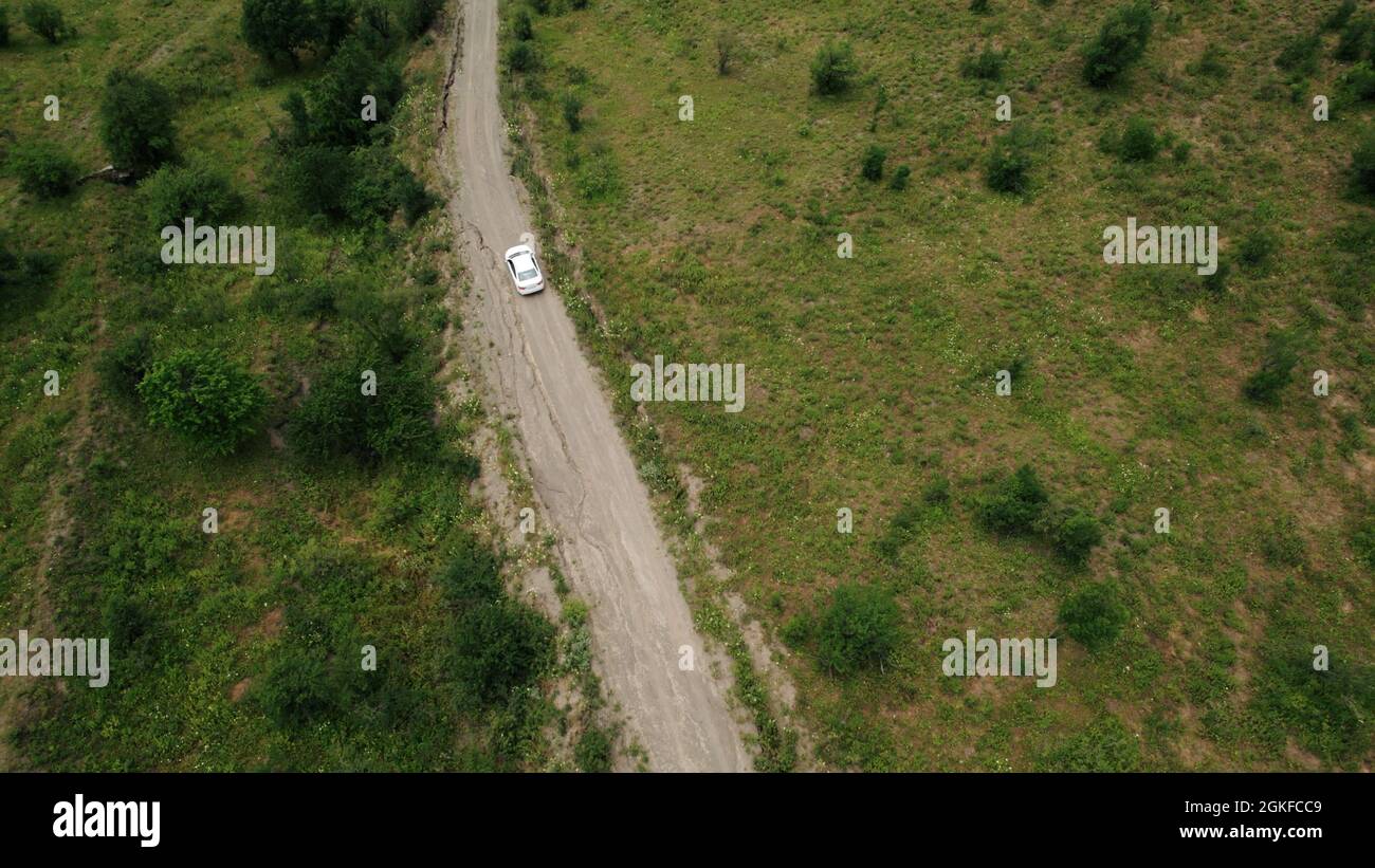 Flying above the countryside summer landscape with a driving lonely car ...