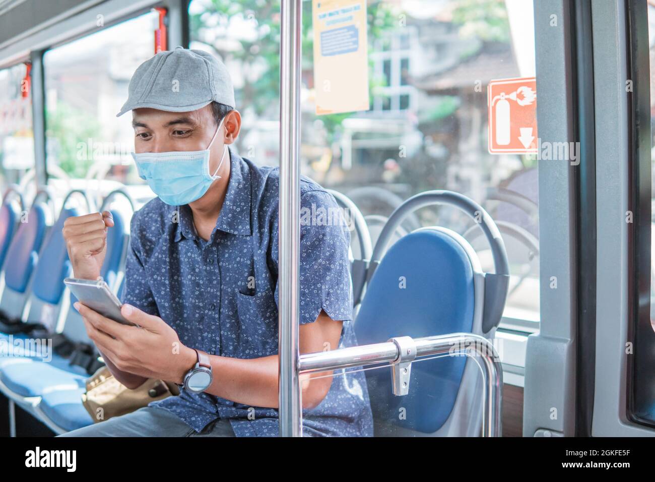 Happy asian man cheering celebrating looking at smartphone while in ...