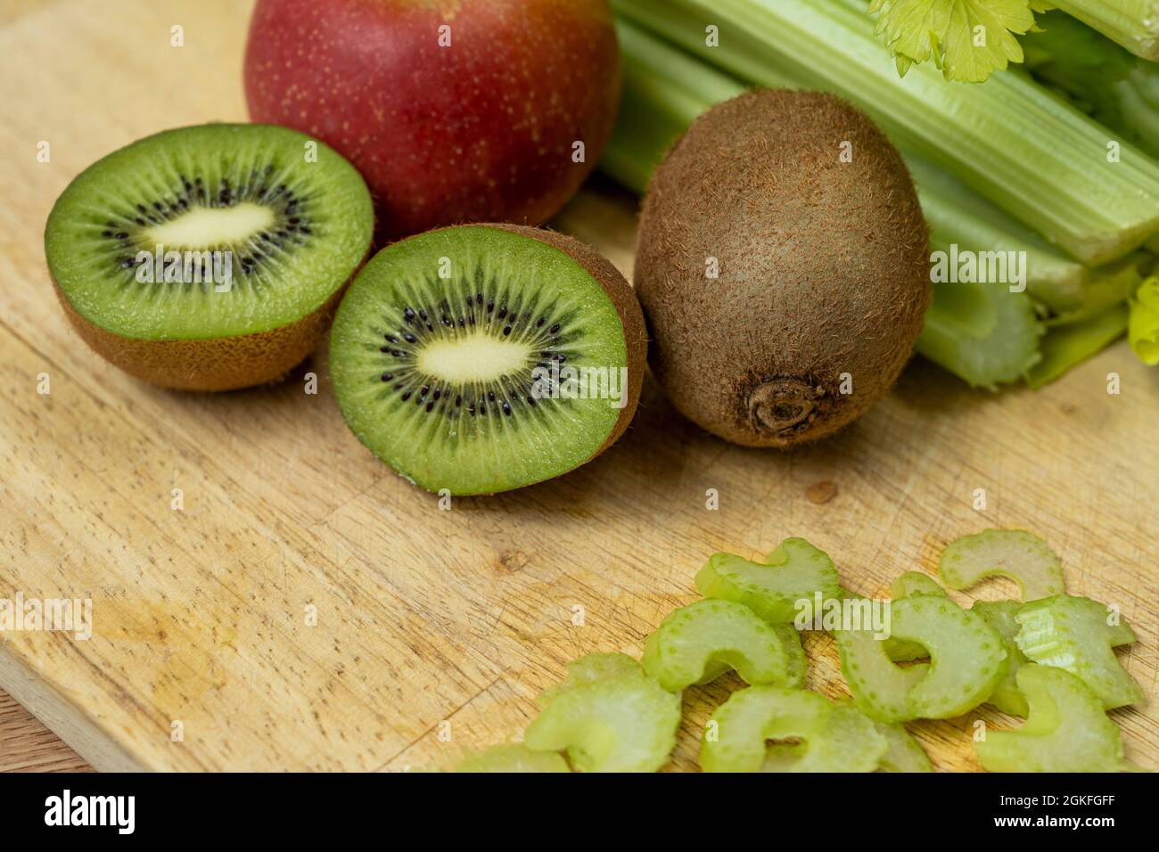 Split kiwis, chopped celery and whole apple to make detox juice on ...