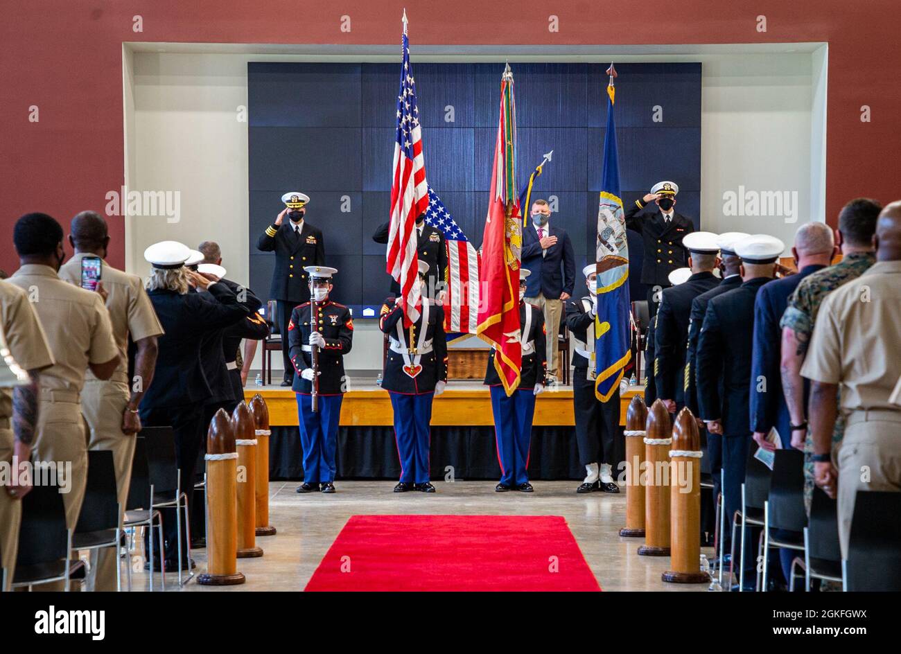 U.S. Navy sailors and U.S. Marines stand at attention during a ...
