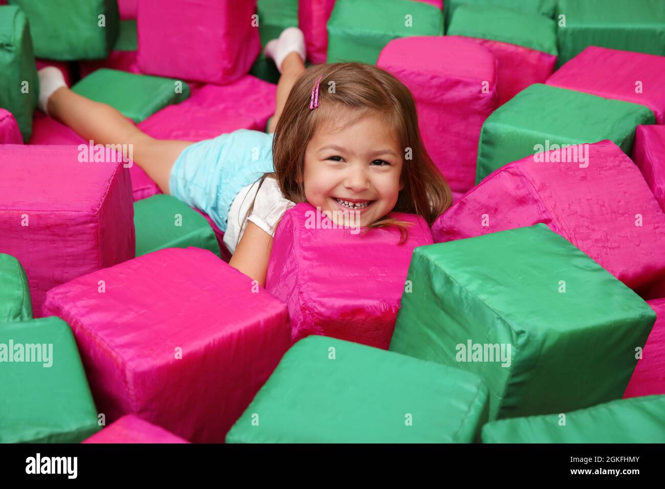 Cute girl playing among soft cubes Stock Photo - Alamy