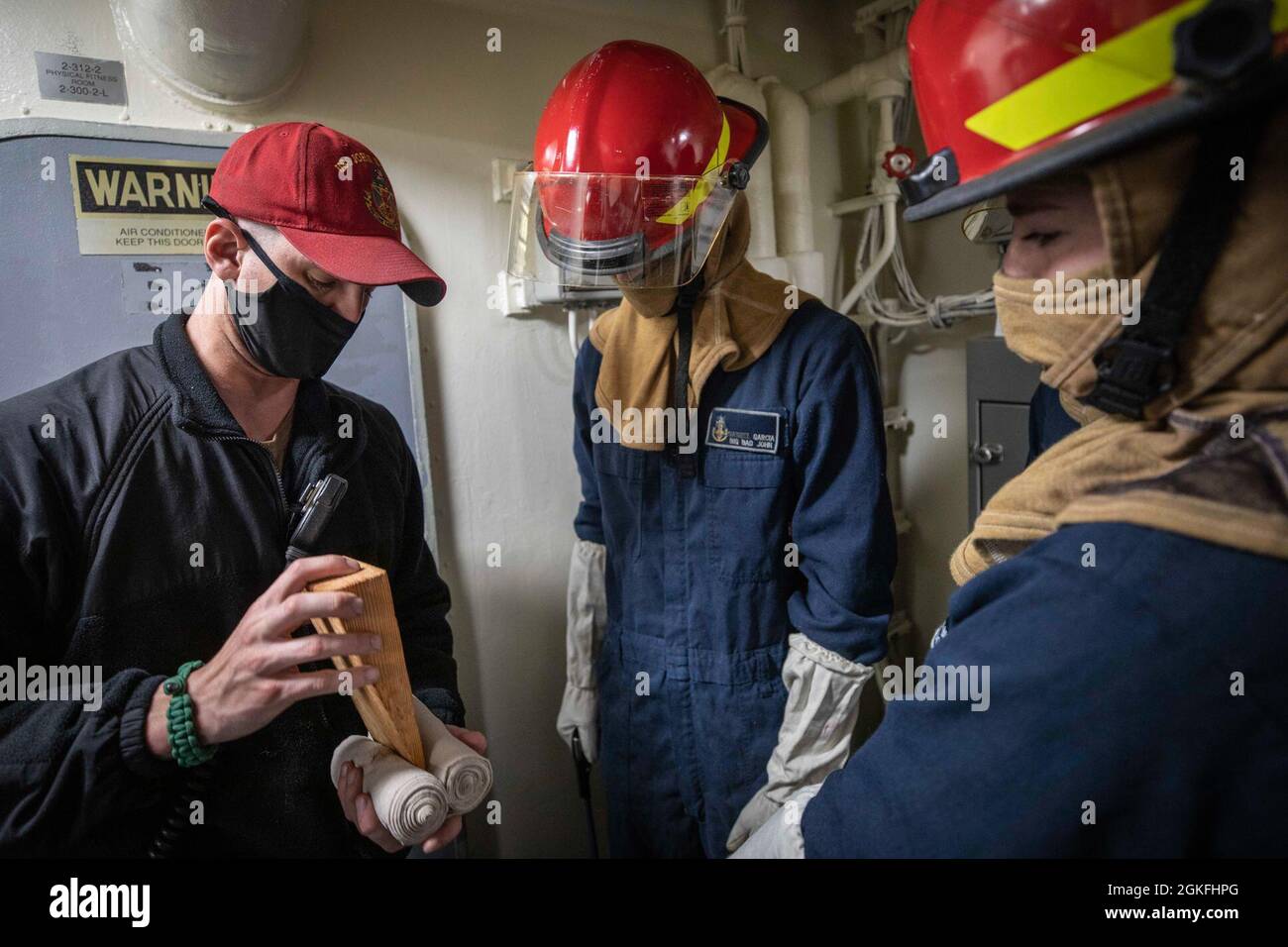 Damage Controlman Chief William Bullock demonstrates a pipe patching ...