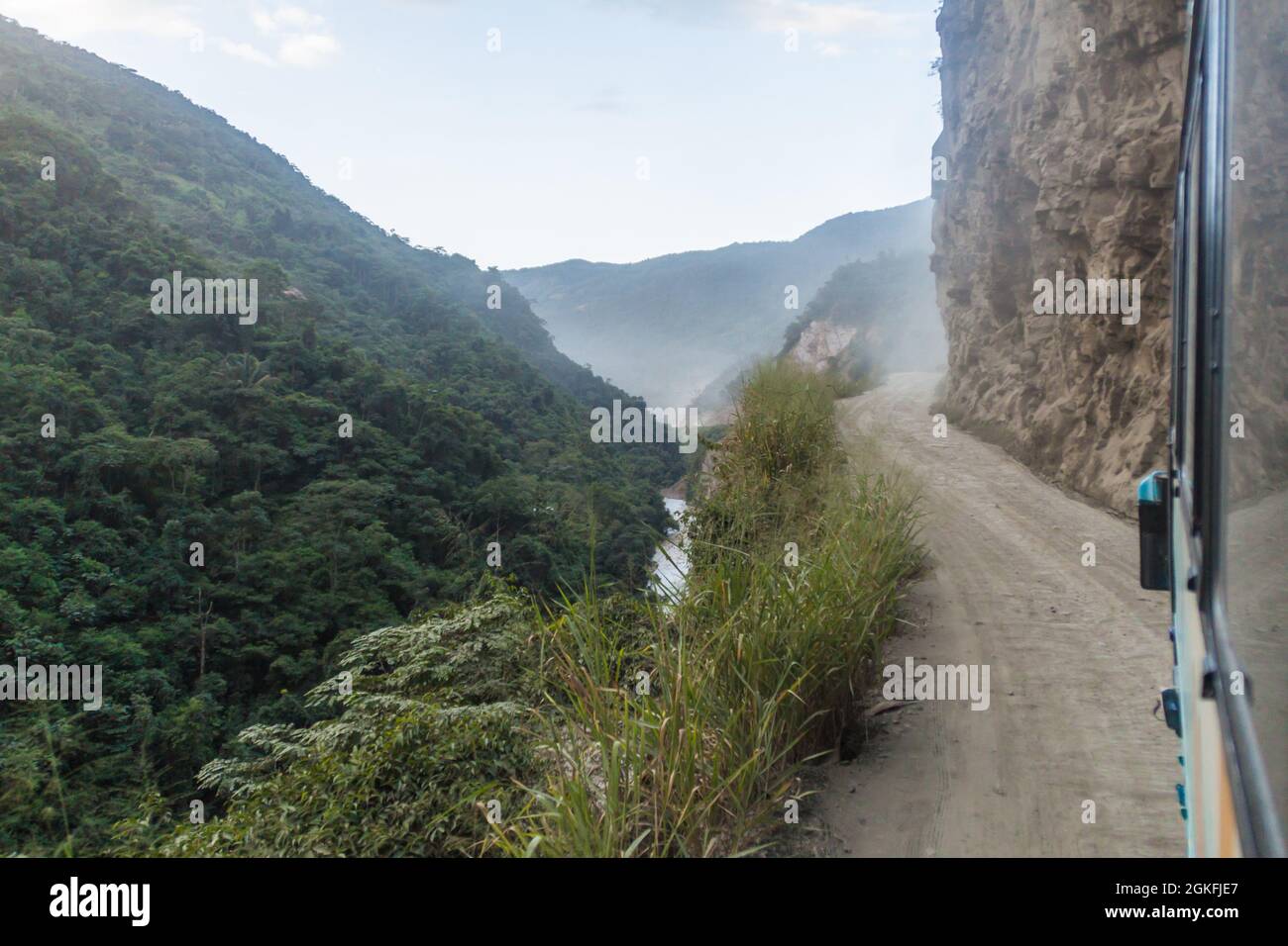 Narrow dangerous road in a valley of Coroico river in Yungas mountains ...