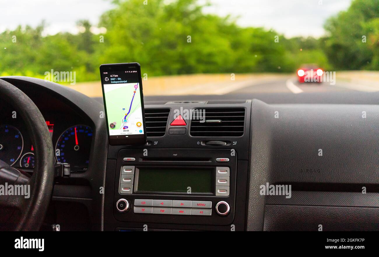 Driving and using waze maps application on smartphone on car dashboard ...