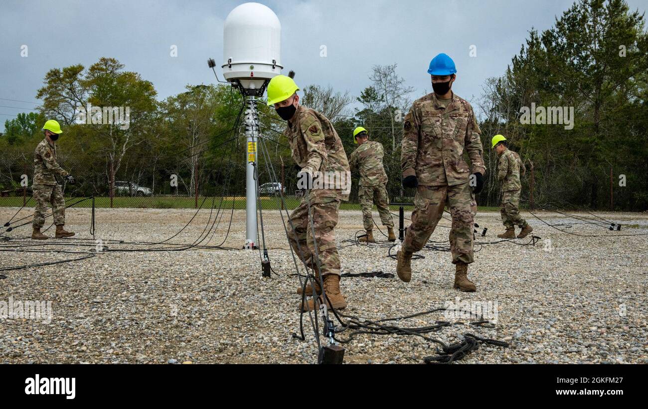 Members of the 2nd Combat Weather Systems Squadron lower a portable ...