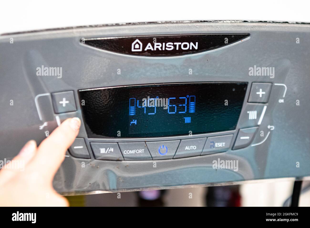 Girl hand setting temperature to heating system. Central heating ...