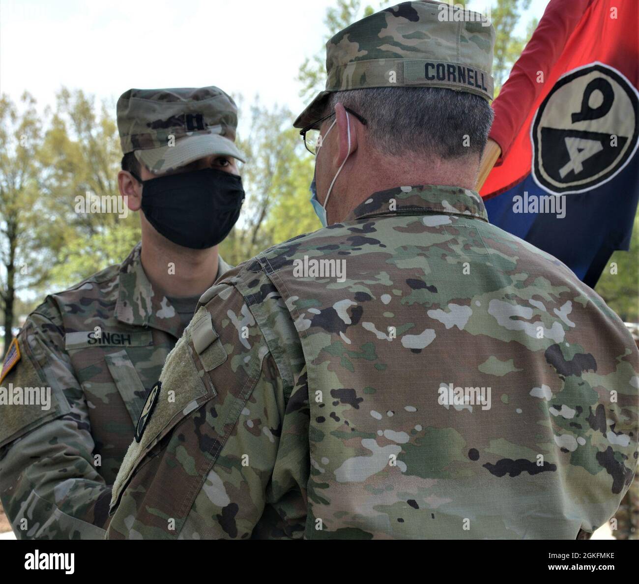 Capt. Alex Singh, outgoing commander (left), passes the unit guidon to ...