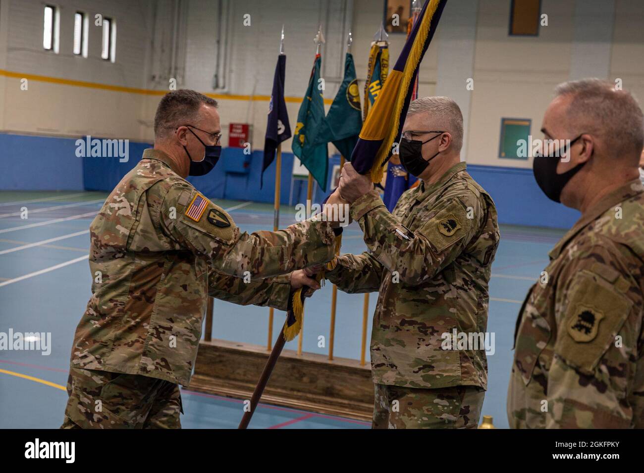 U.S. Army Command Sgt. Maj. Mark Leonard, left, passes the guidon to ...