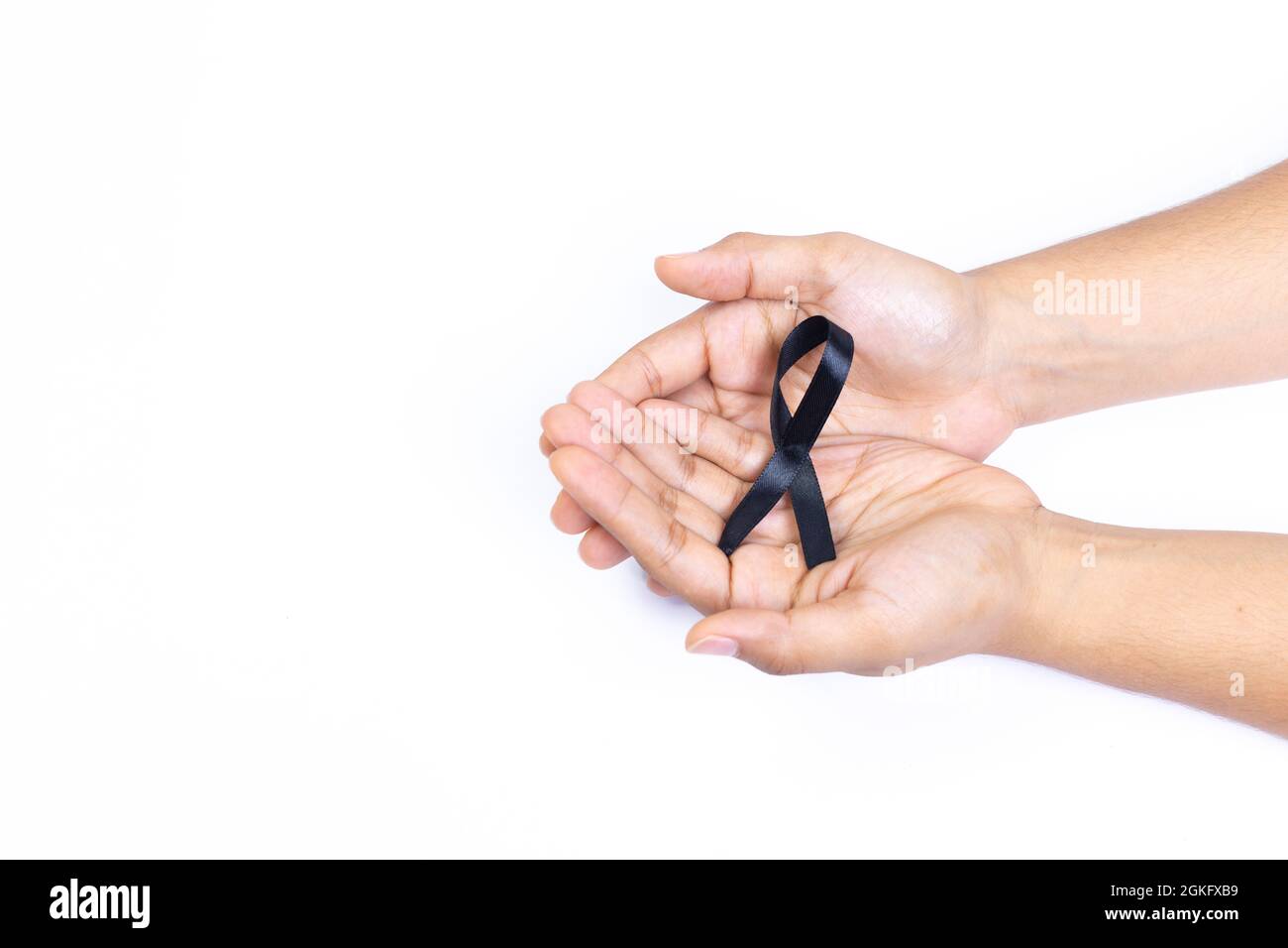 Two hands holding black ribbon, symbol of melanoma cancer on white ...
