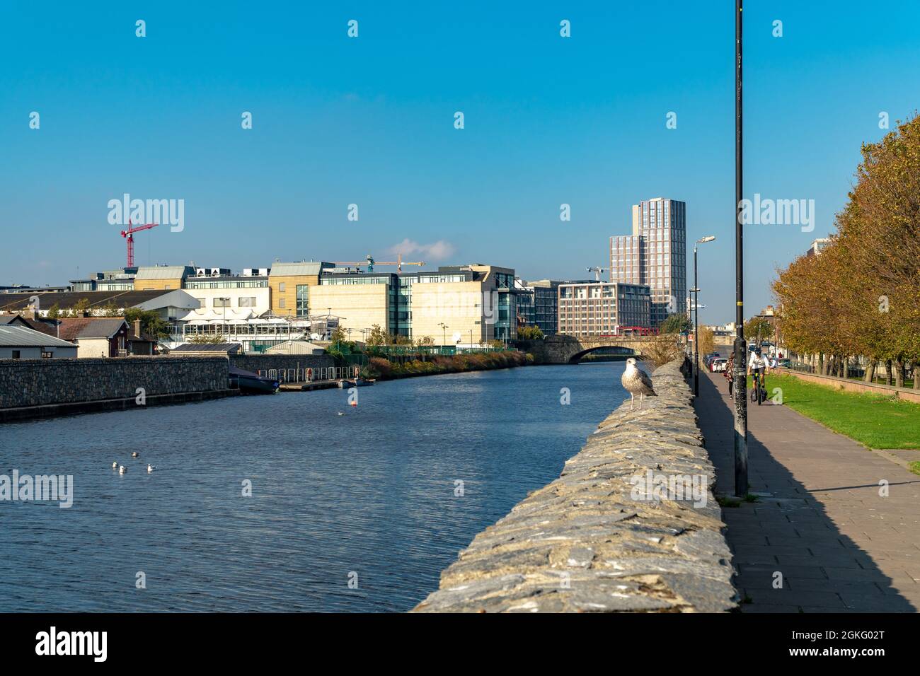 River water flowing through the city with high buildings and a park ...