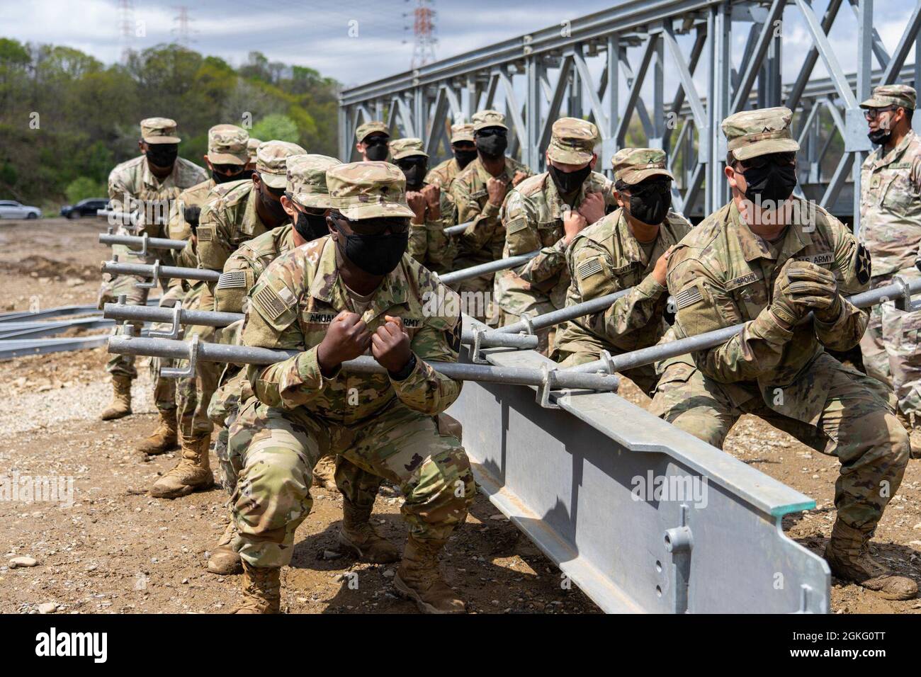 Soldiers of the 2nd Infantry Division work together to lift a 900 ...