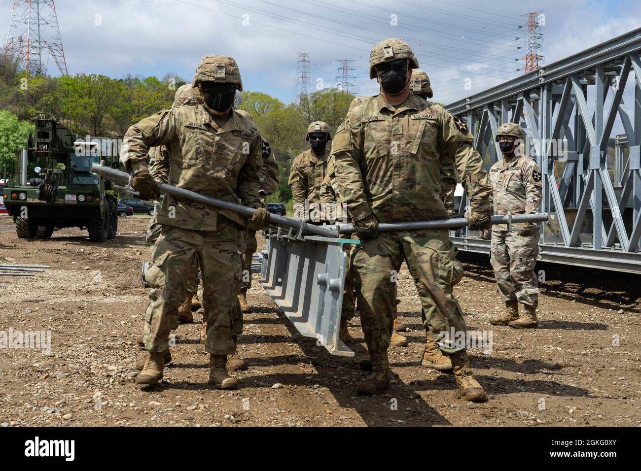 Soldiers of the 2nd Infantry Division work together to lift a 900 ...