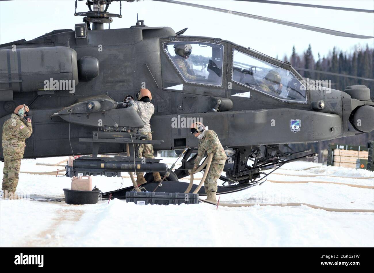 Ground crew members work to refuel an AH-64 Apache with 1st Attack ...