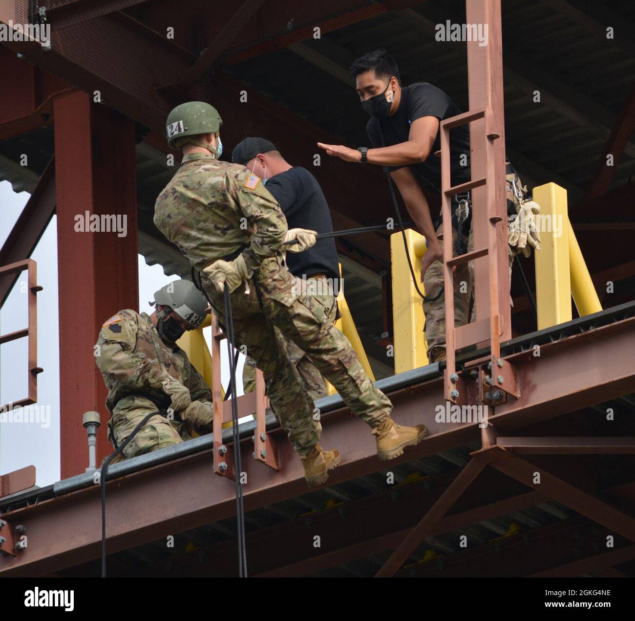 (Right to Left) An Air Assault cadre signals to the next Soldier for ...