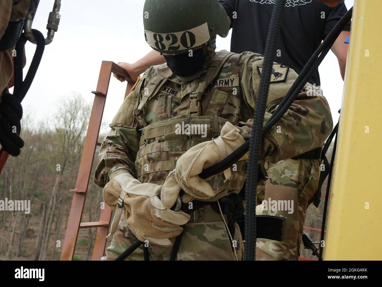A Soldier is tested on hooking up to the rope at the top of the rappel ...