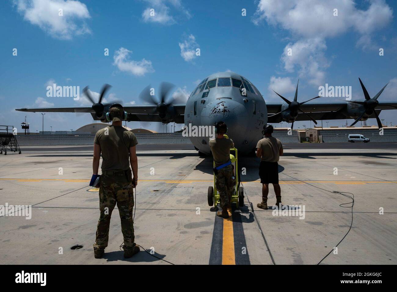 A U.S. Air Force loadmaster and two crew chiefs watch engine power up ...