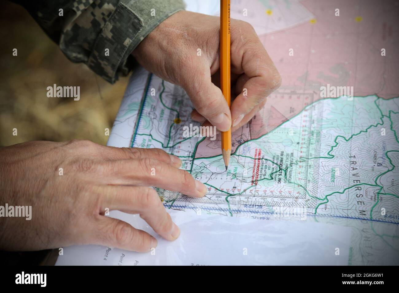 An Army Reserve Soldier plots points on a map at a land navigation ...