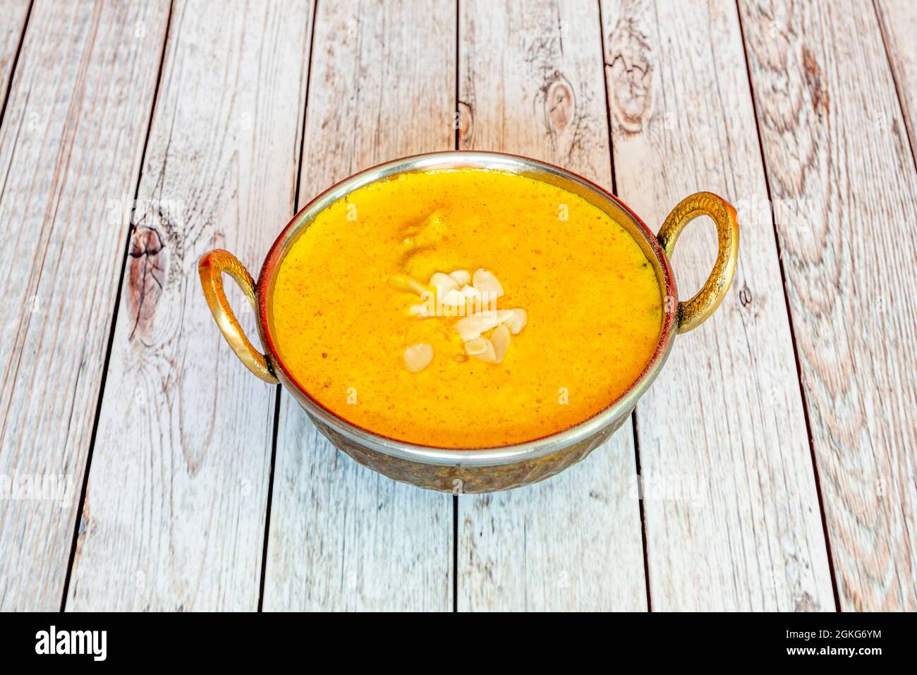 Traditional hindu yellow korma chicken recipe inside a traditional bowl ...