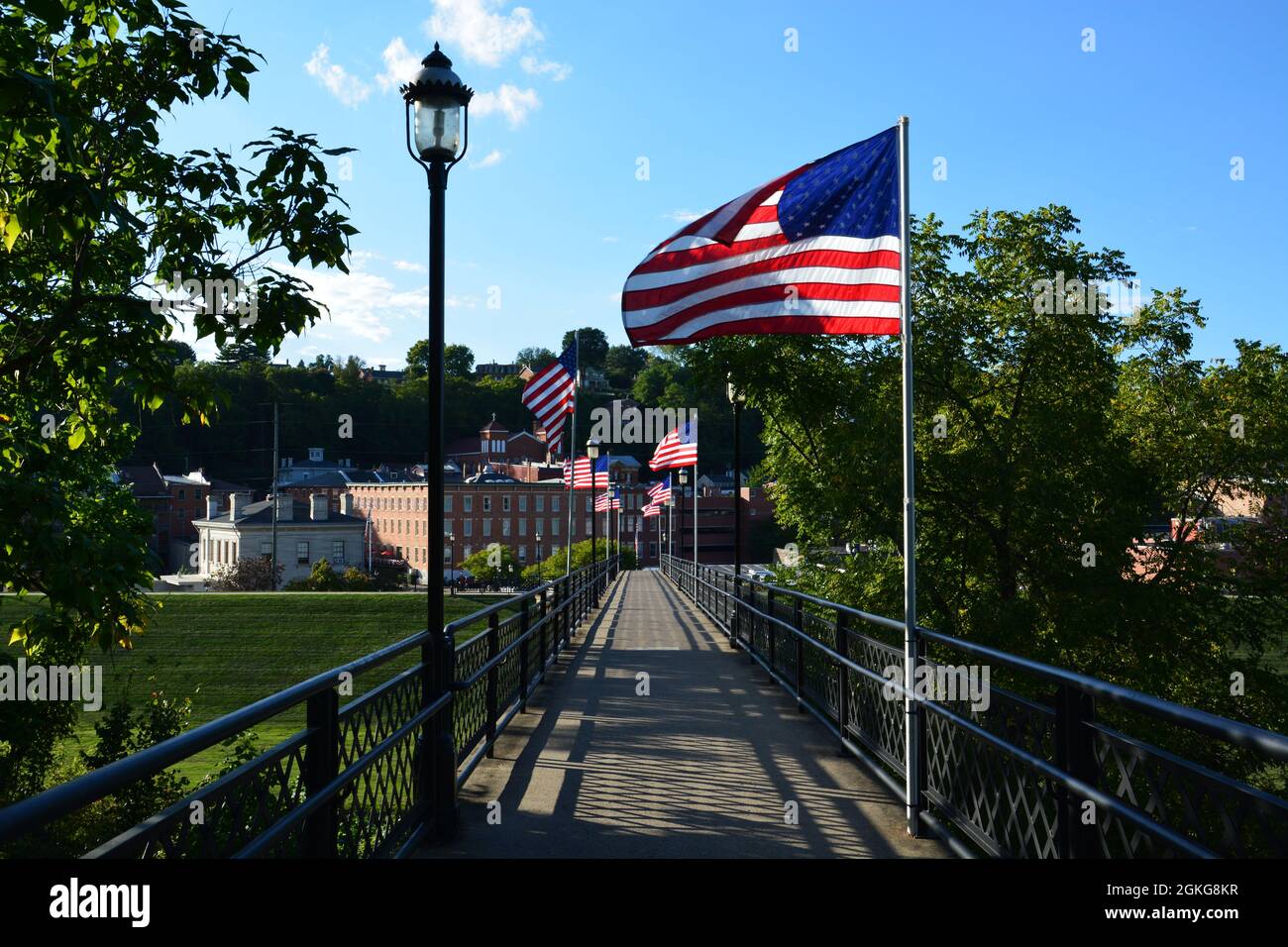 Flags waiving in the breeze line a pedestrian bridge over the river in ...