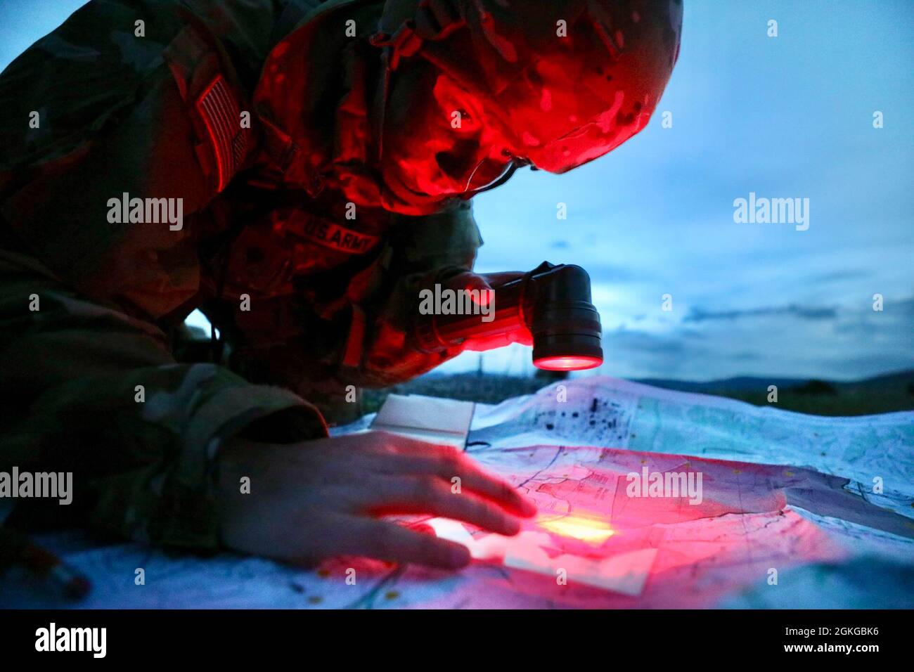 An Army Reserve Soldier uses a red lens on her flashlight to plot ...
