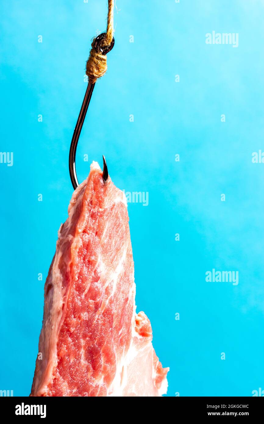 The bait on the hook. A piece of raw meat. Pork steak Stock Photo - Alamy