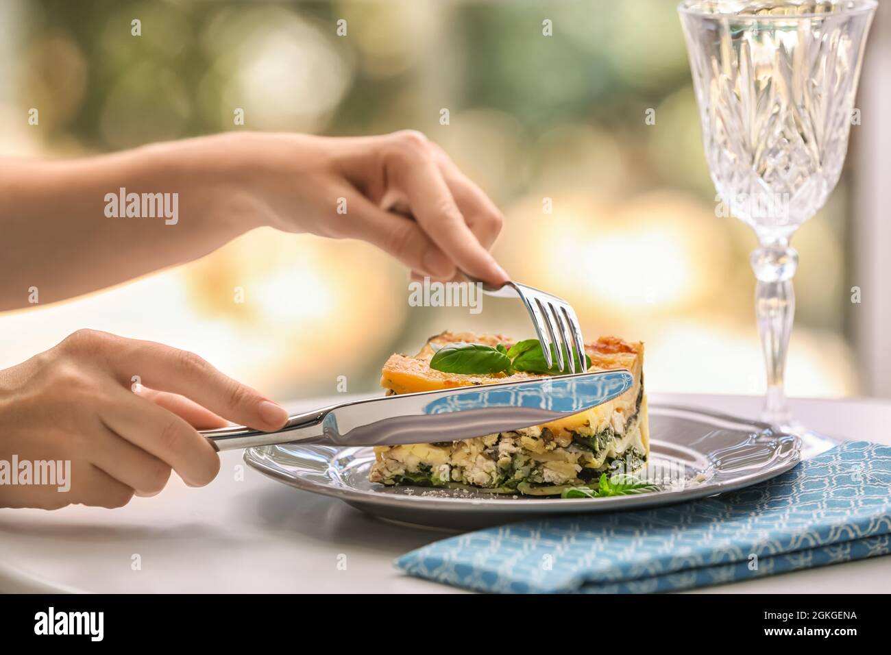 Woman eating lasagna with spinach in restaurant Stock Photo - Alamy