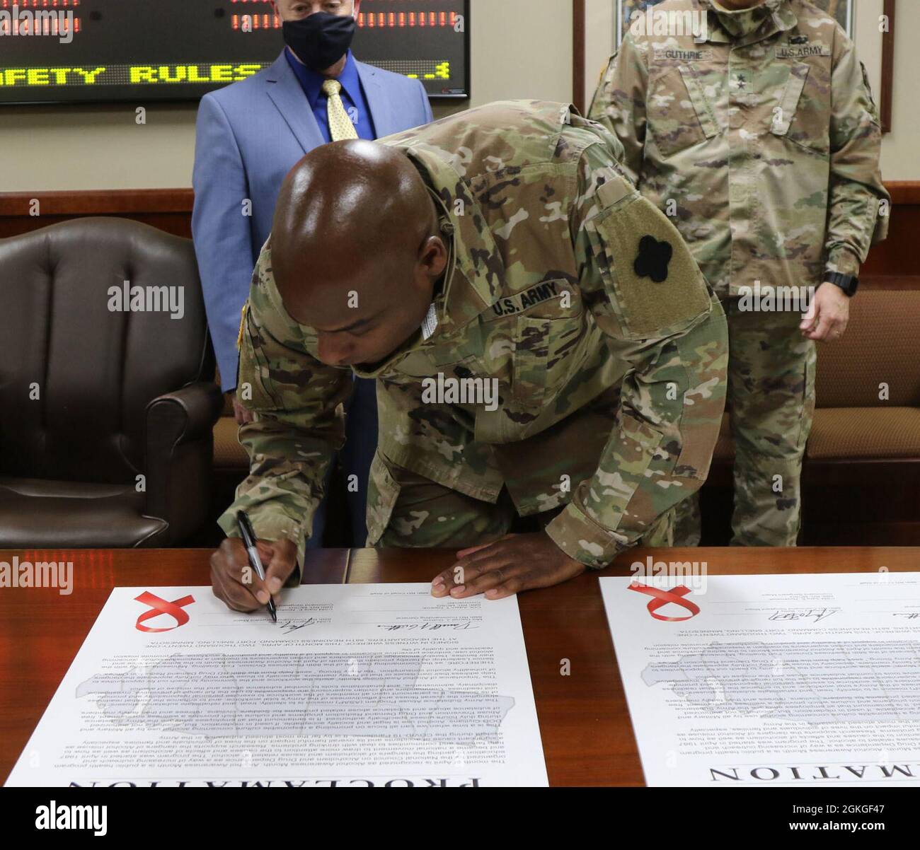 88th Readiness Division Command Sgt. Maj. Gregory Betty signs the ...