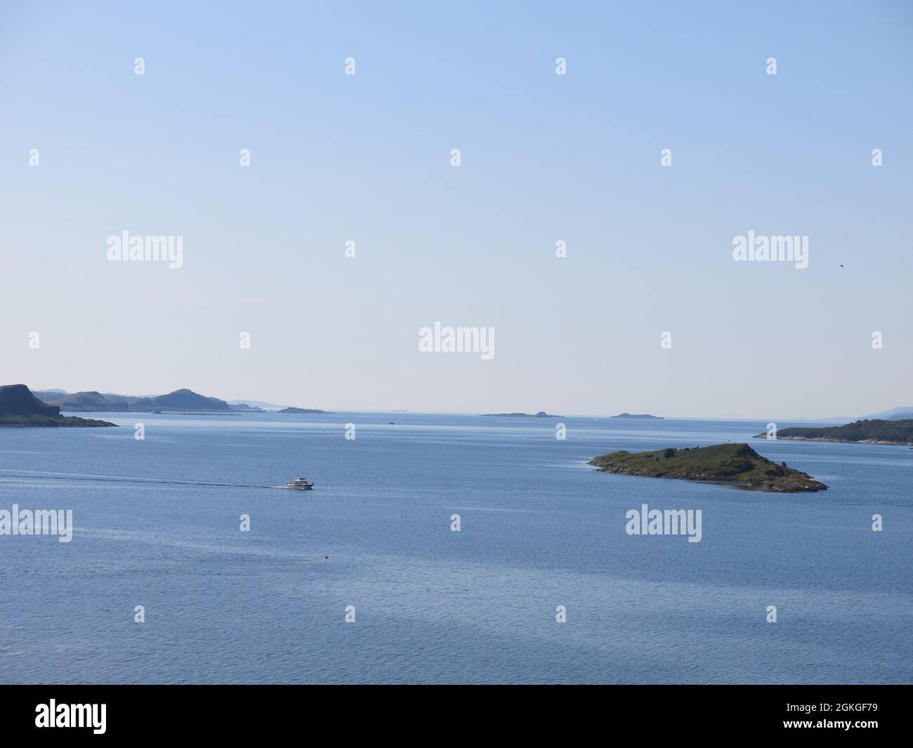 Tiny boat in the distance making its way across flat calm seas in the ...