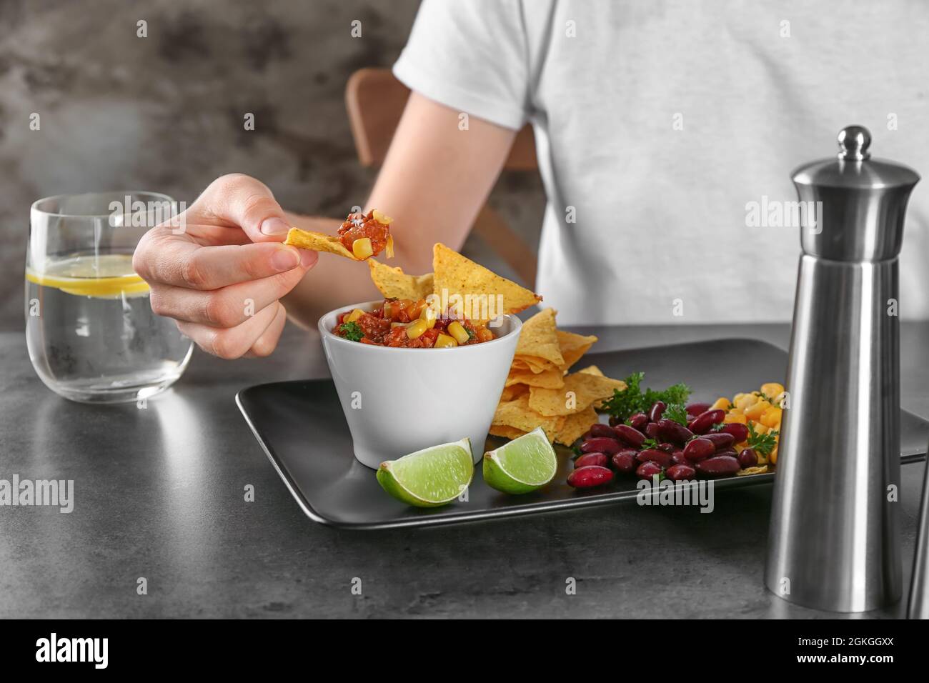 Woman eating nacho with chili con carne in cafe Stock Photo - Alamy