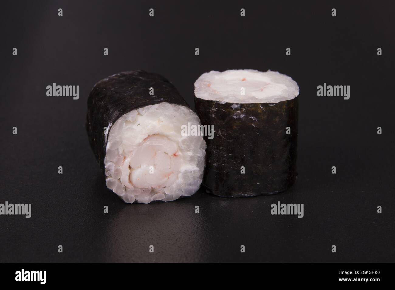 Closeup of classic maki sushi rolls with shrimp on a black background ...