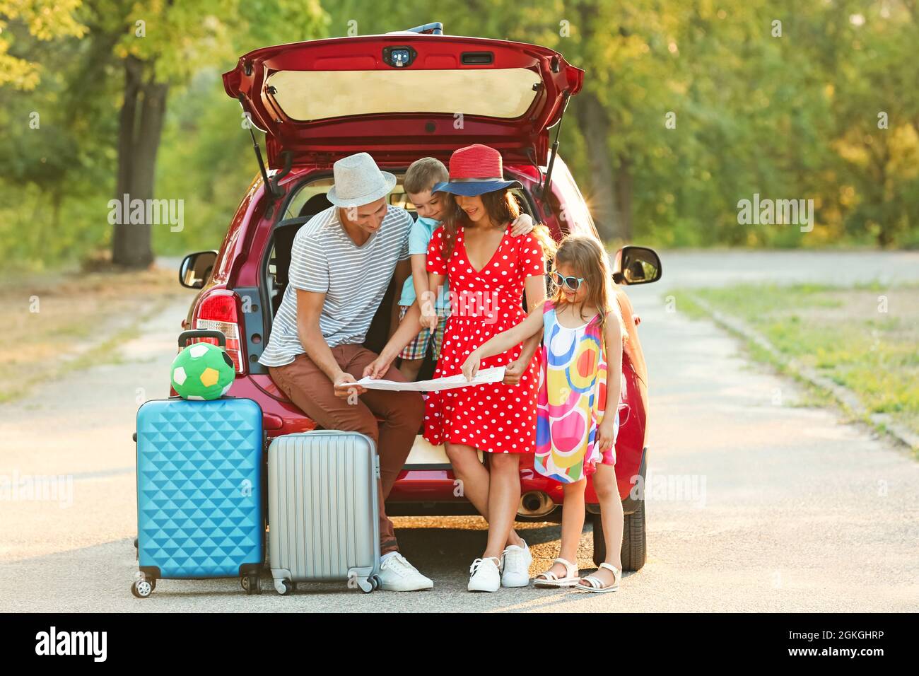 Happy family looking at map next to car in countryside Stock Photo - Alamy