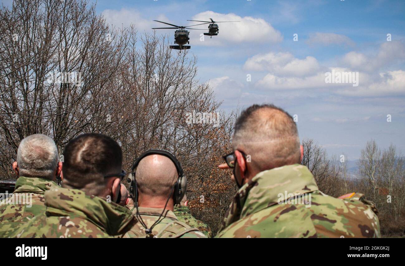 U.S. Soldiers assigned to Regional Command-East, Kosovo Force, watch as ...