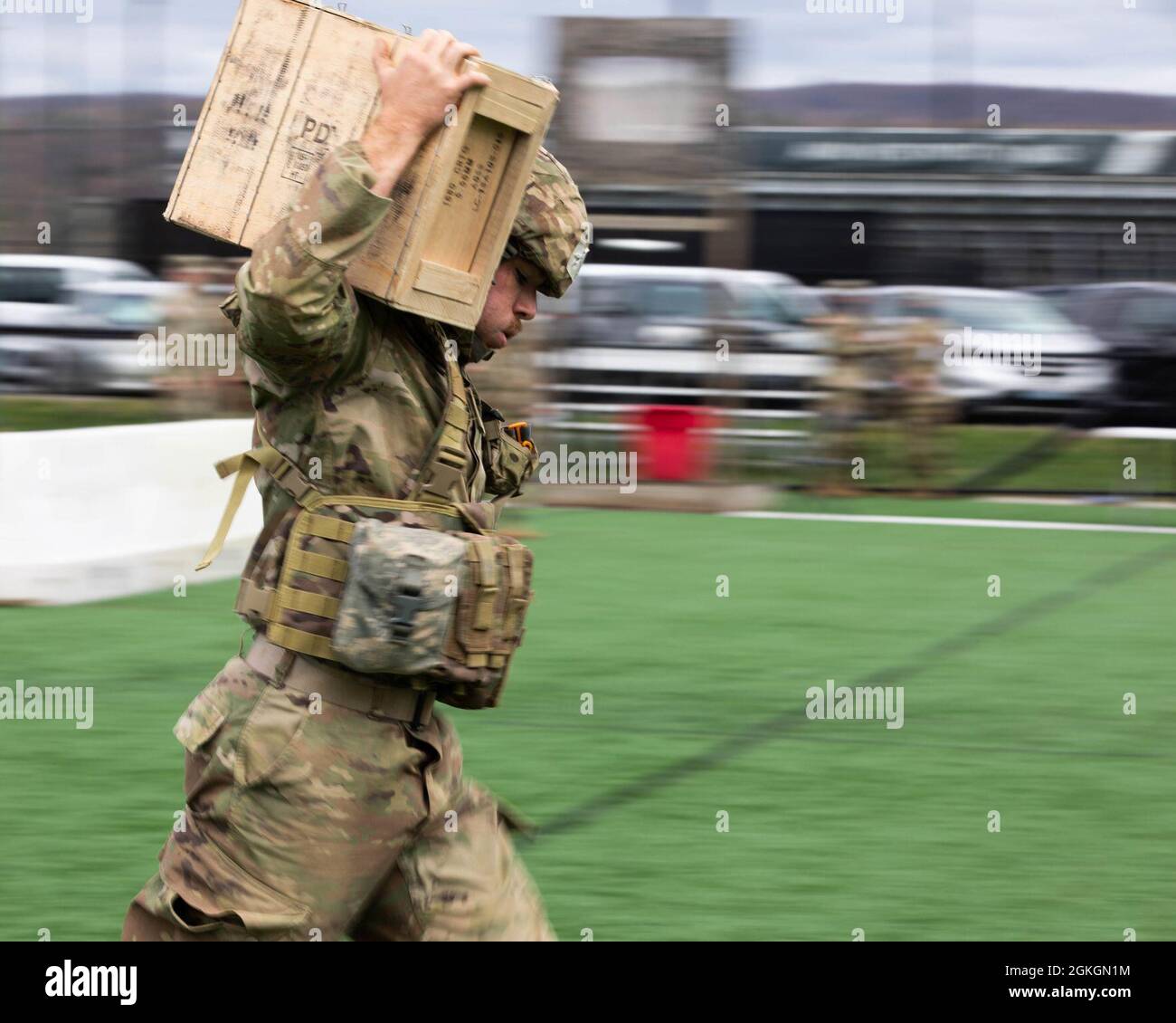 A U.S. Army cadet sprints with a heavy box of ammunition during the ...