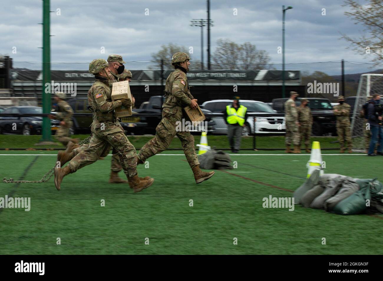 U.S. Army cadets sprint with a heavy boxes of ammunition during the ...