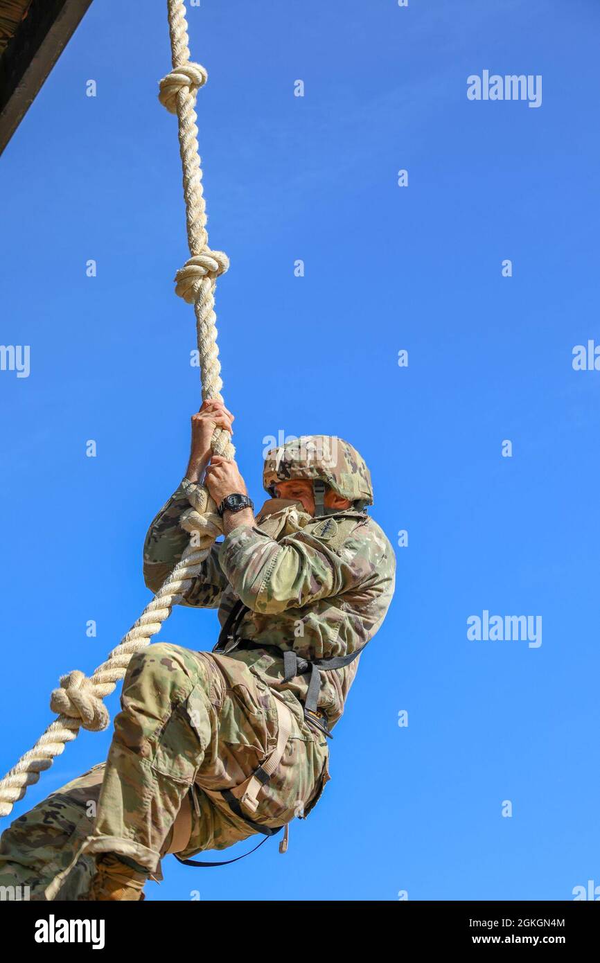 A U.S. Army service member climbs a notched rope at the Tri towers ...