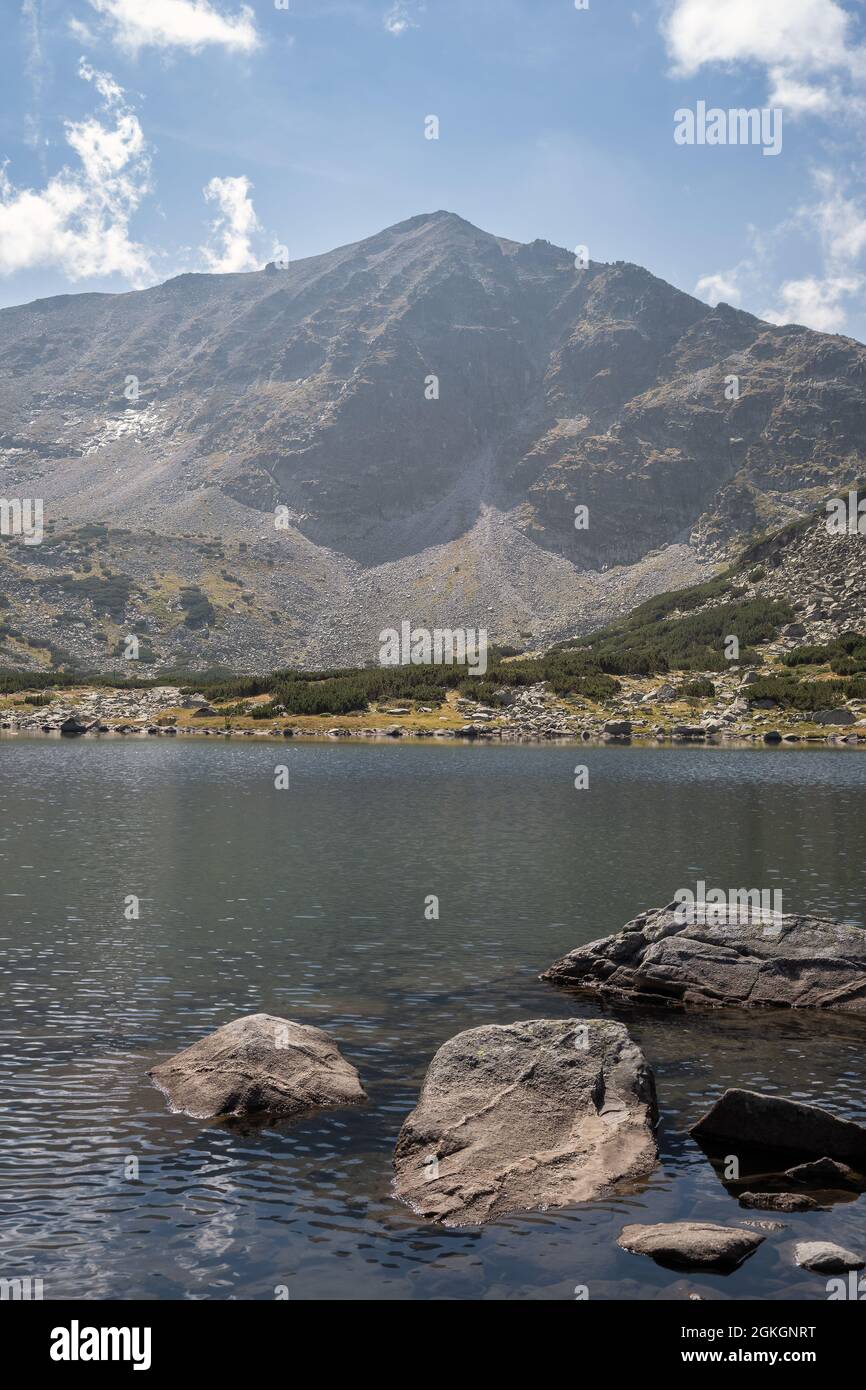View over glacial lake on impressive, pointy peak on Rila mountain on ...