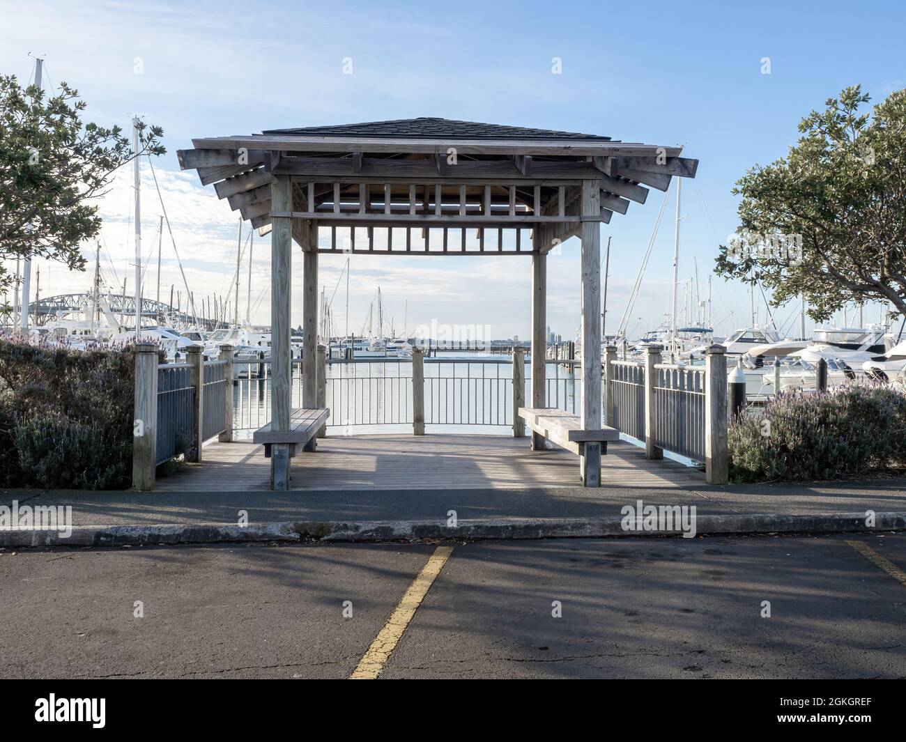 White gazebo at seashore with port with boats Stock Photo - Alamy