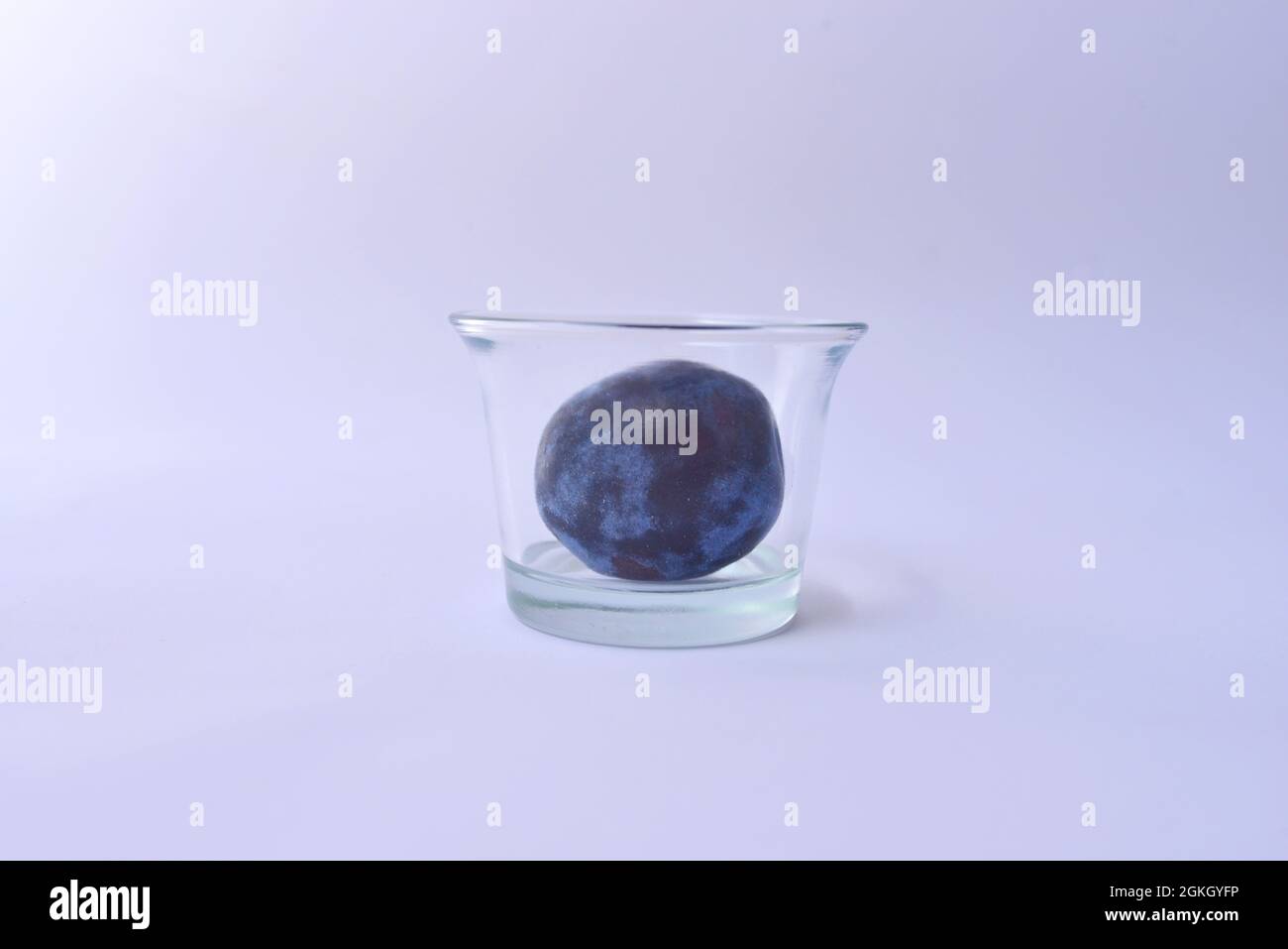 Plum in glass on white background Stock Photo - Alamy