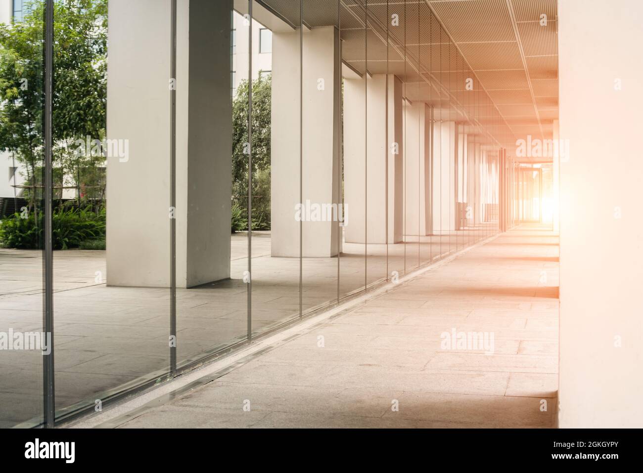 Corridor of a modern building with the sun shining through its glass ...