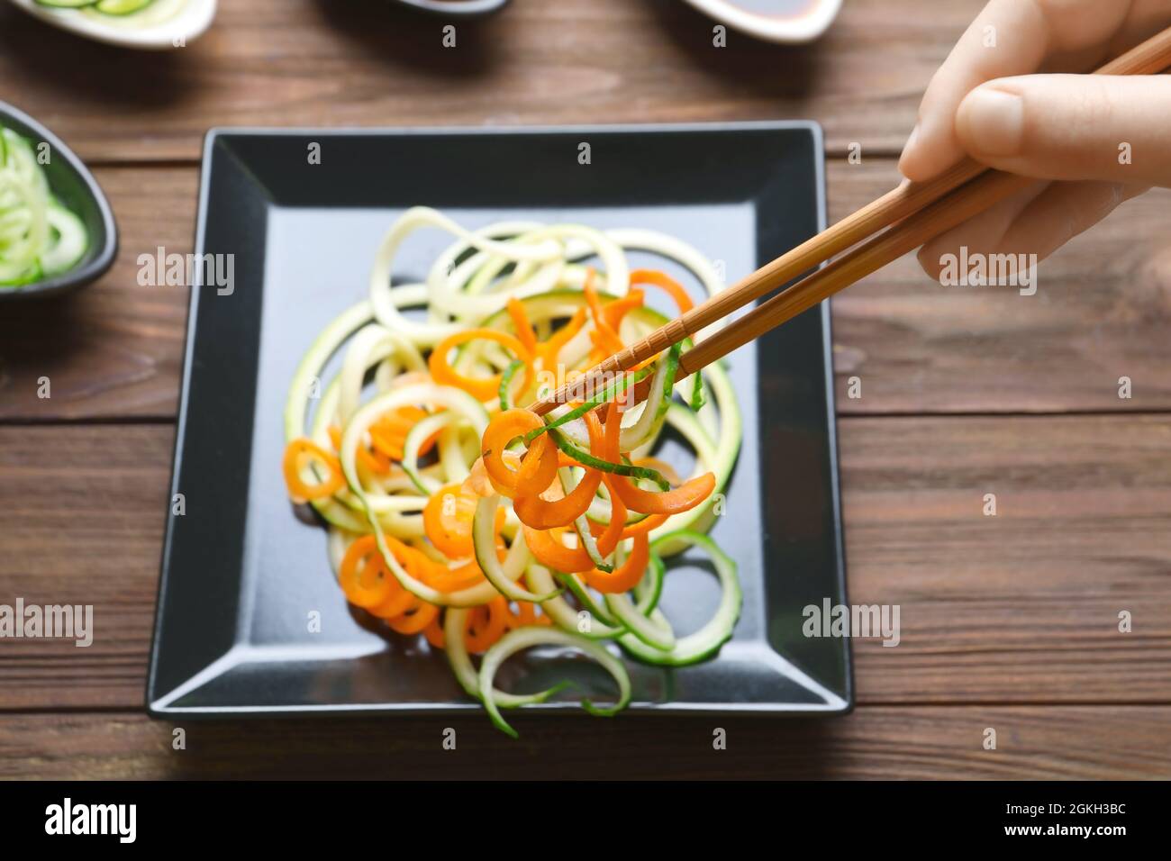 Woman eating raw vegetable spaghetti with chopsticks Stock Photo - Alamy