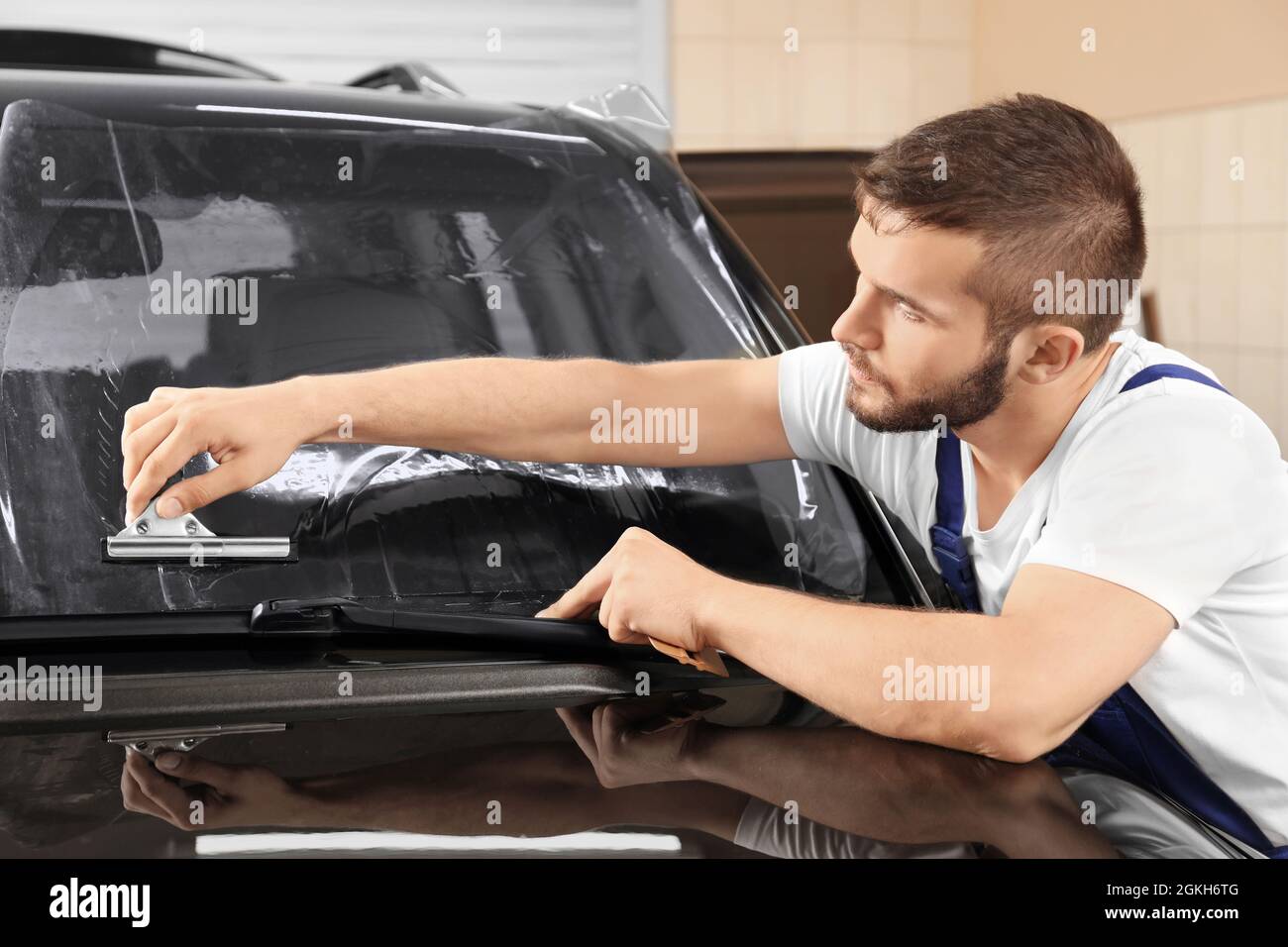 Worker tinting car window in shop Stock Photo - Alamy